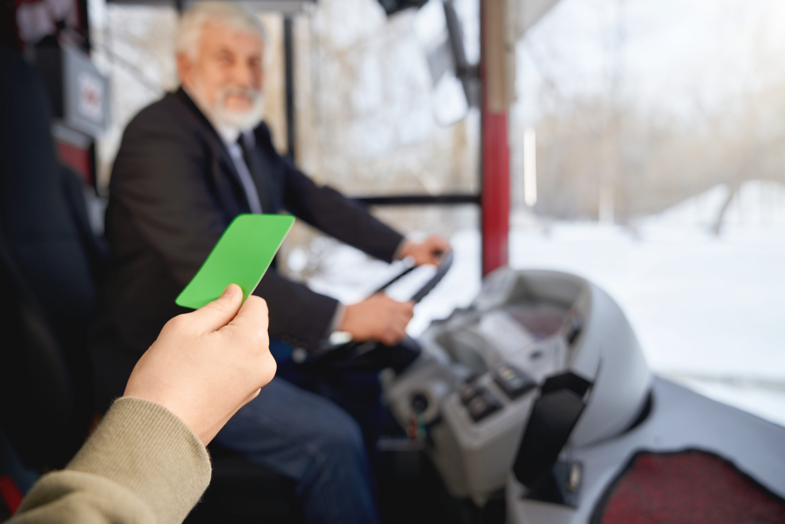Hand of passenger showing green ticket to elderly bus driver while ...